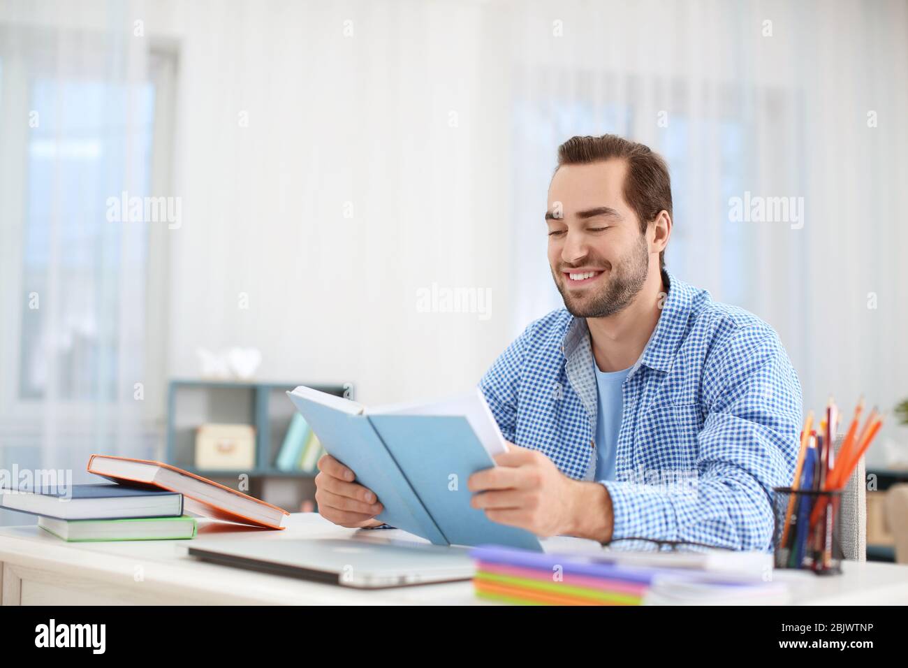 Student studying at table indoors Stock Photo - Alamy