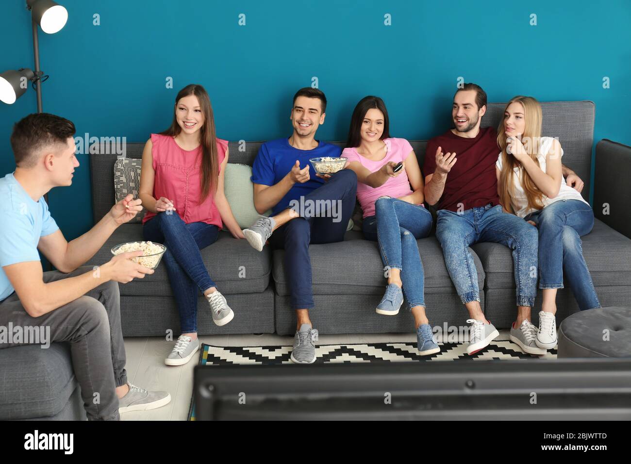 Young people watching movie in home cinema Stock Photo - Alamy