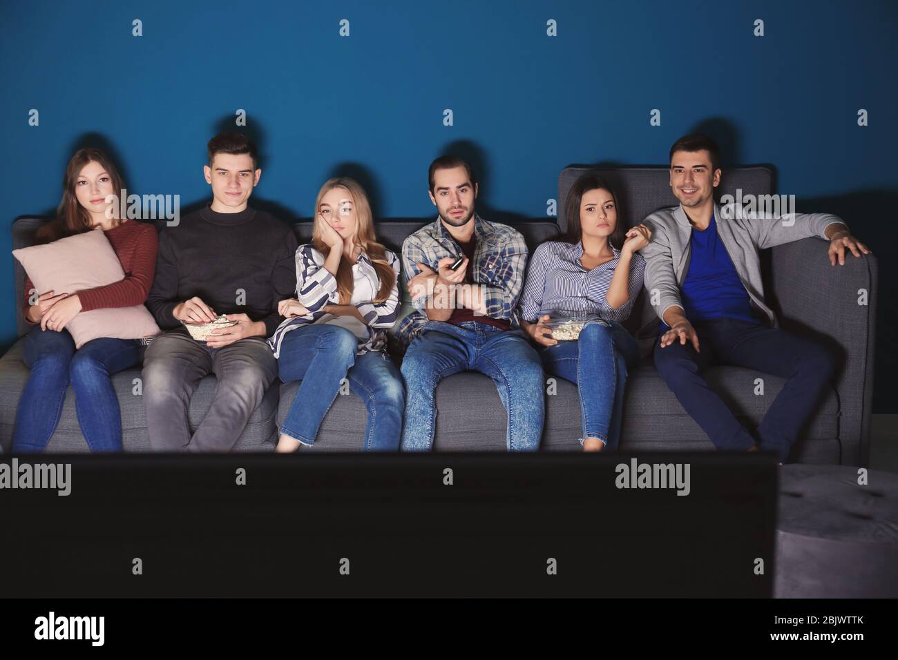 Young people watching movie in home cinema at night Stock Photo - Alamy