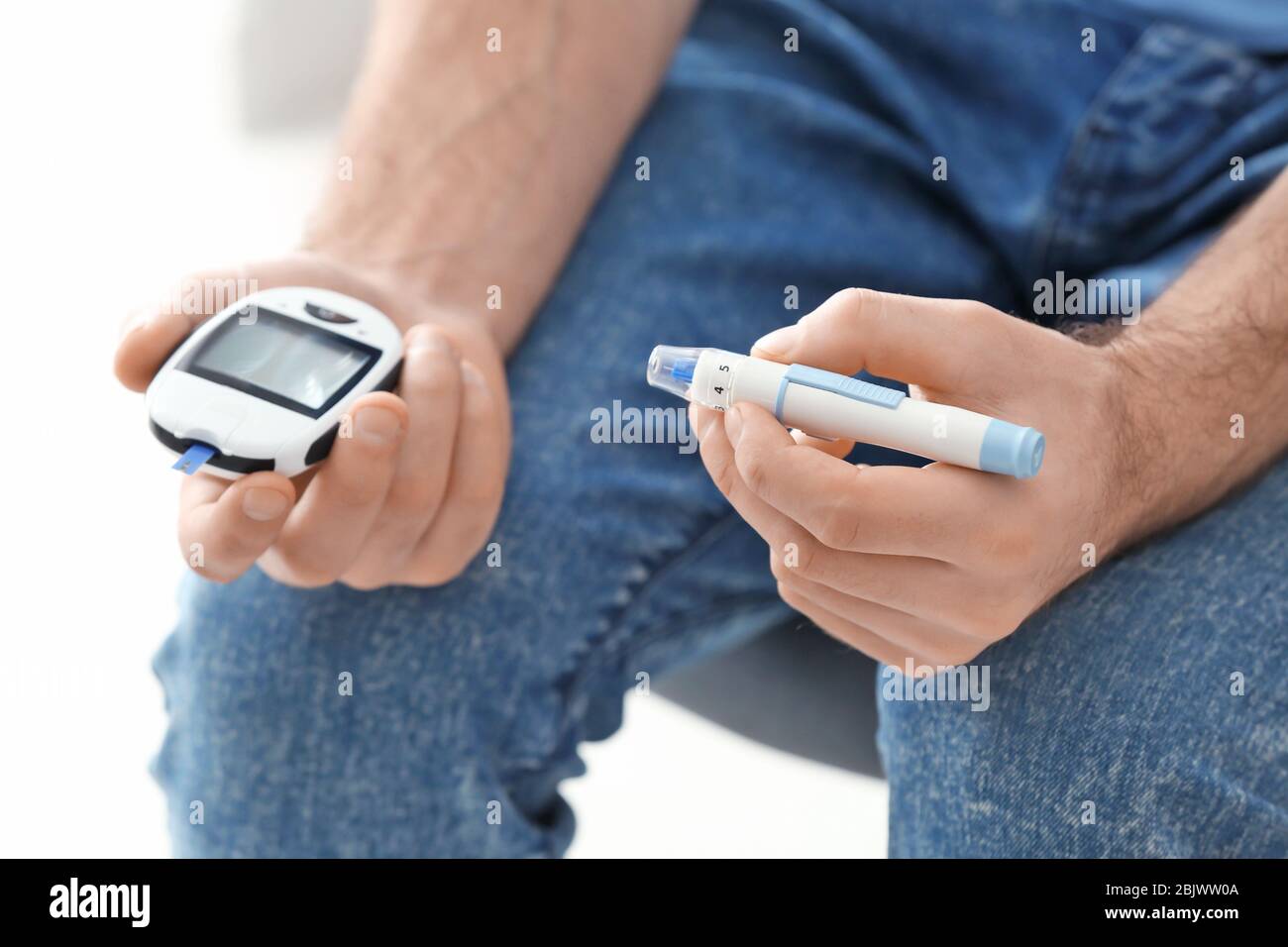Diabetic man holding digital glucometer and lancet pen, closeup Stock ...