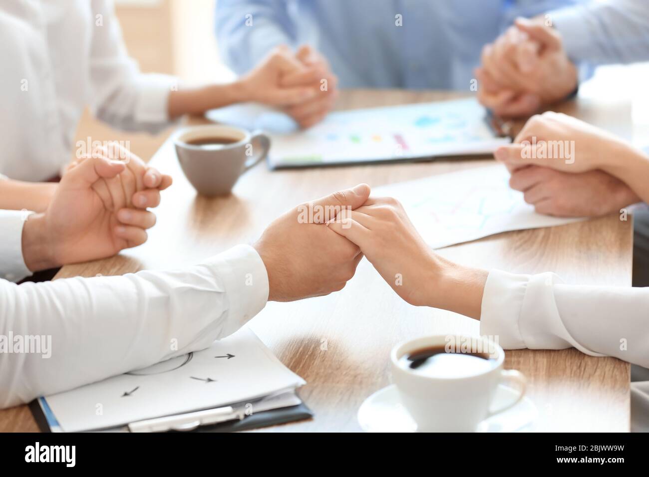 Young people in office wear holding hands indoors. Unity concept Stock ...