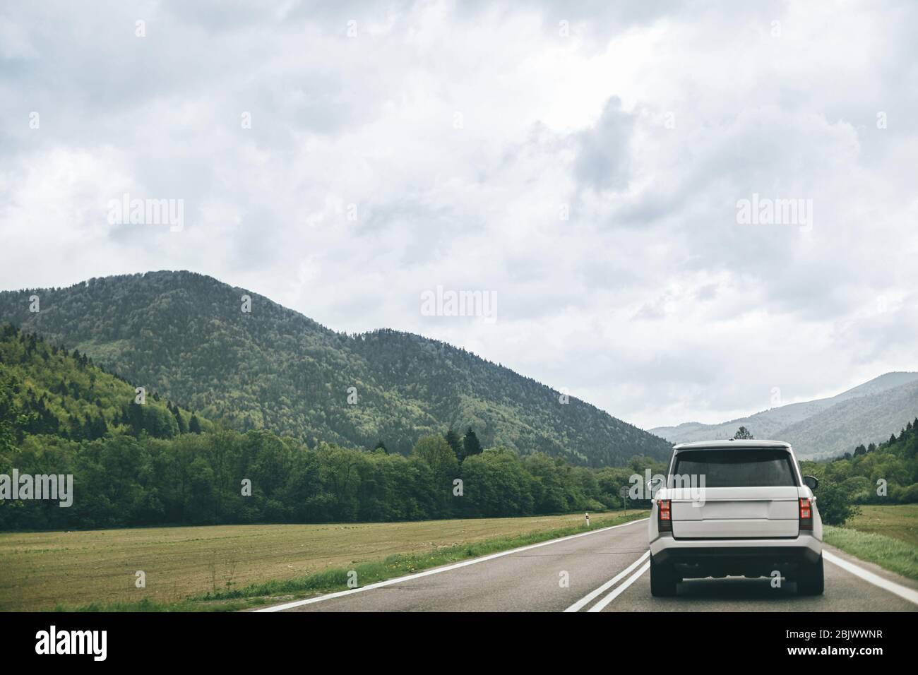 Off-road vehicle on a lonely track. White car on the empty highway ...
