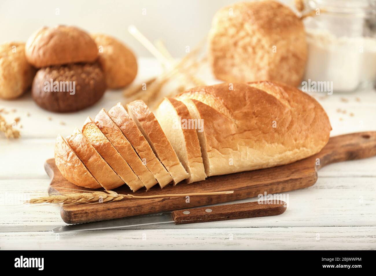 Wooden board with sliced bread on table Stock Photo - Alamy