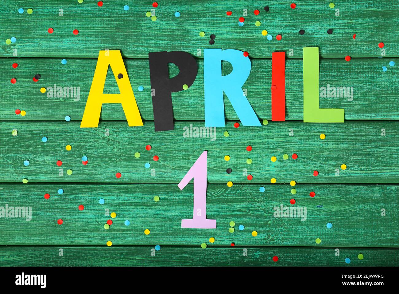 Composition with confetti and phrase "April 1" on color background ...