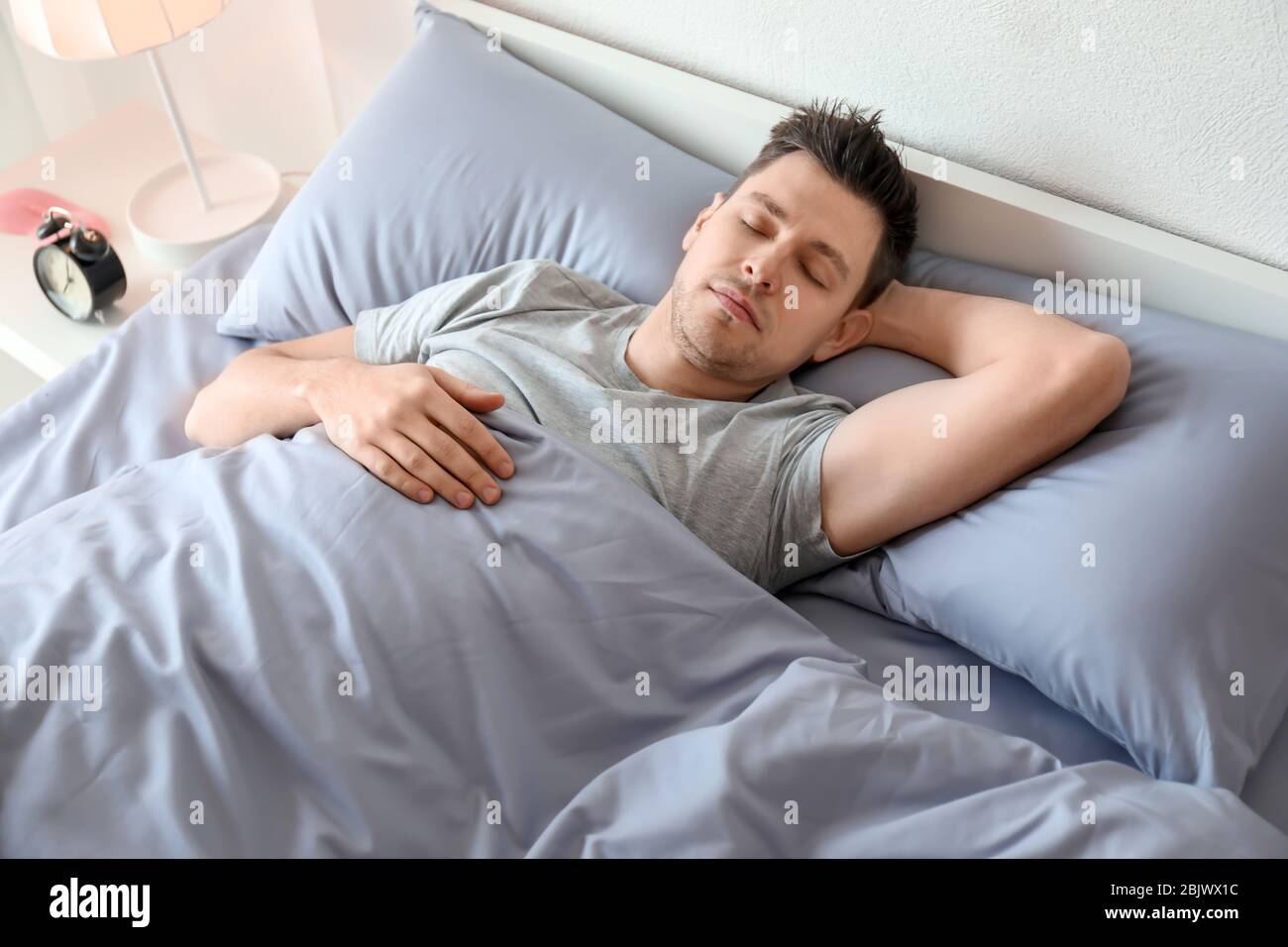 Young man sleeping in bed at home Stock Photo - Alamy