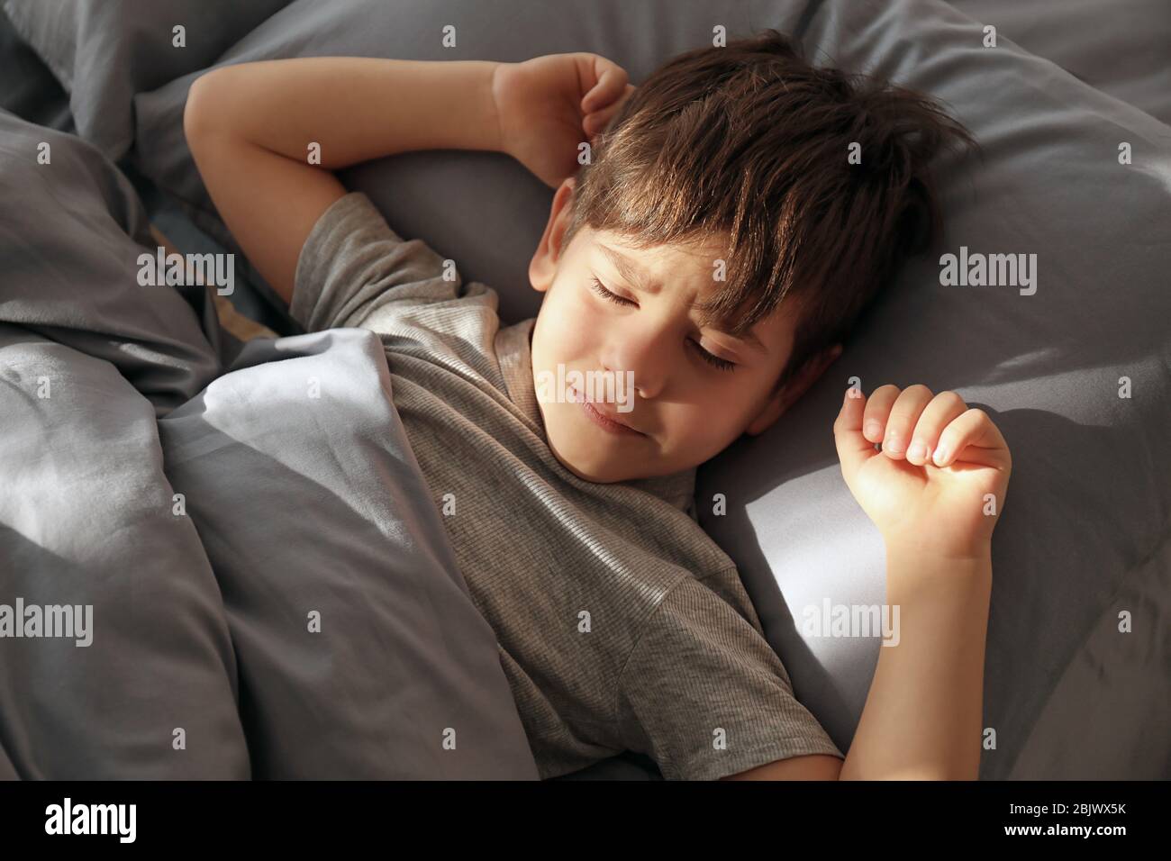 Cute little boy waking up in morning at home Stock Photo - Alamy