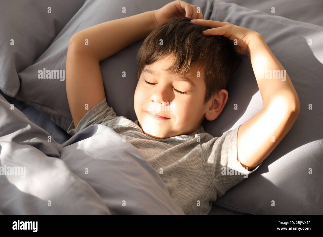 Cute little boy waking up in morning at home Stock Photo - Alamy