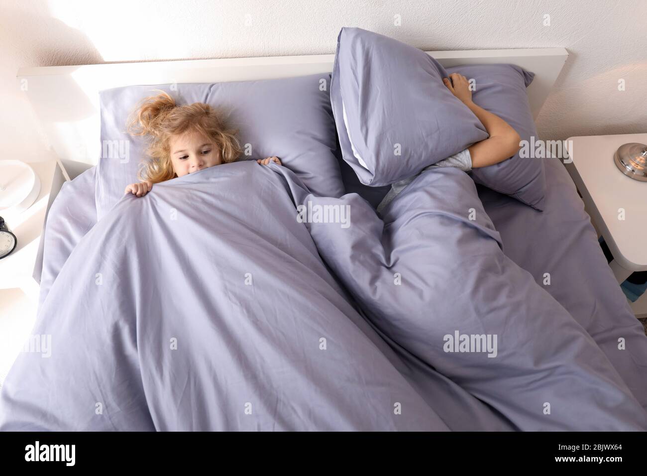 Cute little children trying to fall asleep in bed at home. Family ...