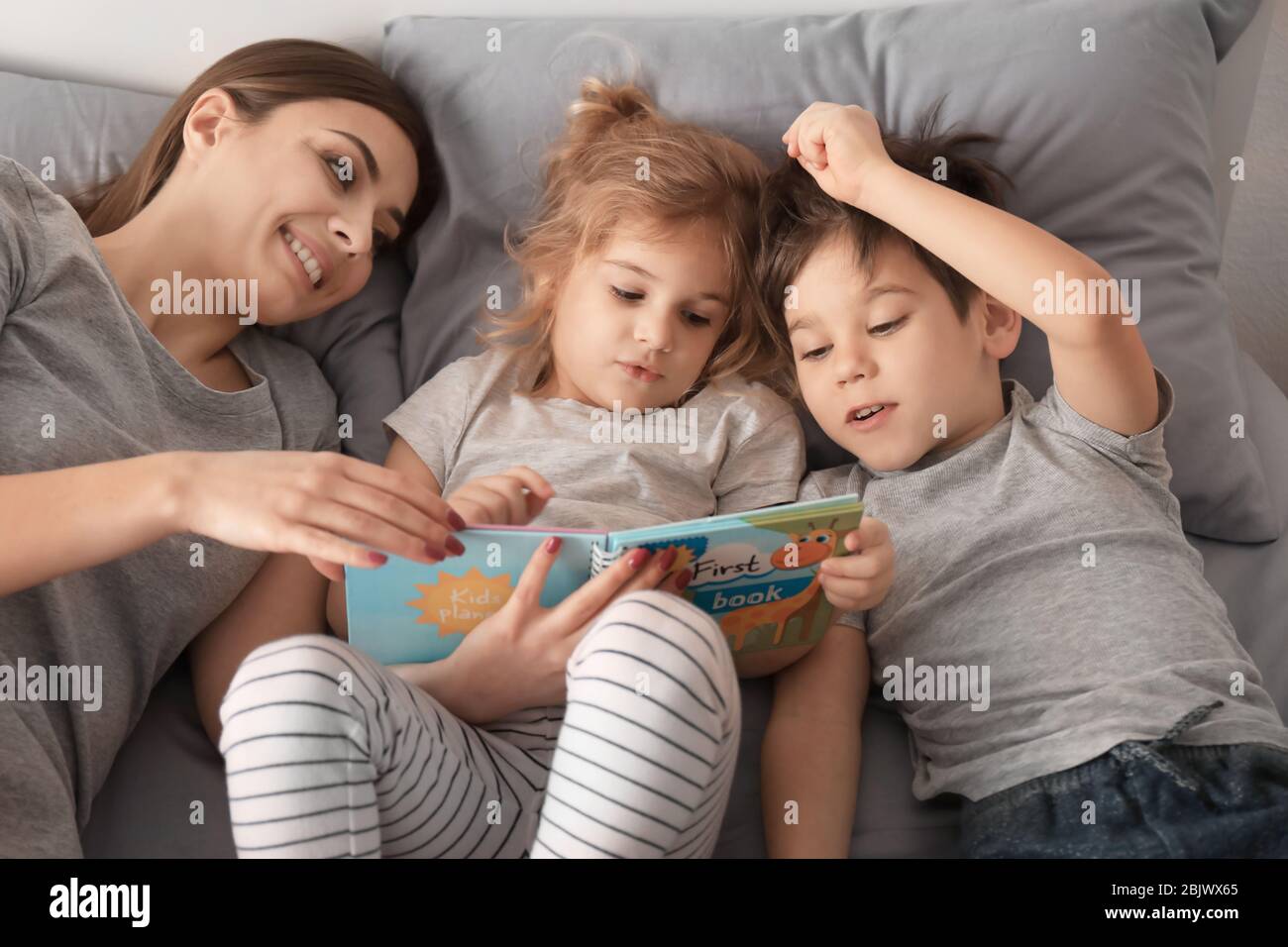 Mother reading bedtime story to children at home Stock Photo - Alamy