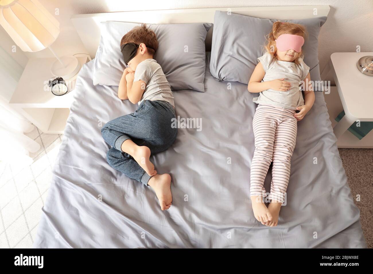 Cute little children sleeping on bed at home. Family bedtime Stock ...