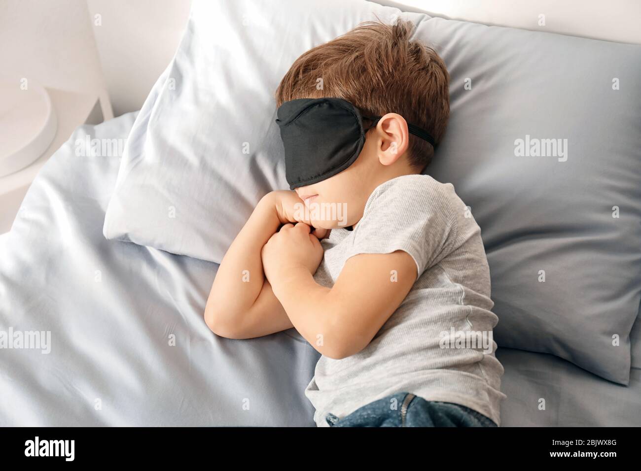 Cute little boy with mask sleeping in bed Stock Photo - Alamy