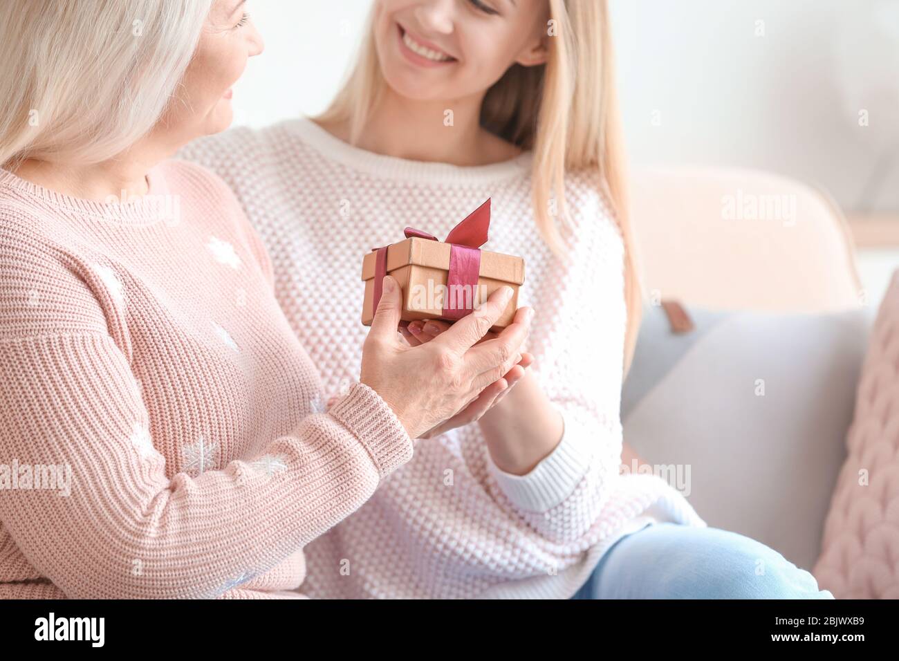 Young daughter giving gift box to mother at home Stock Photo - Alamy
