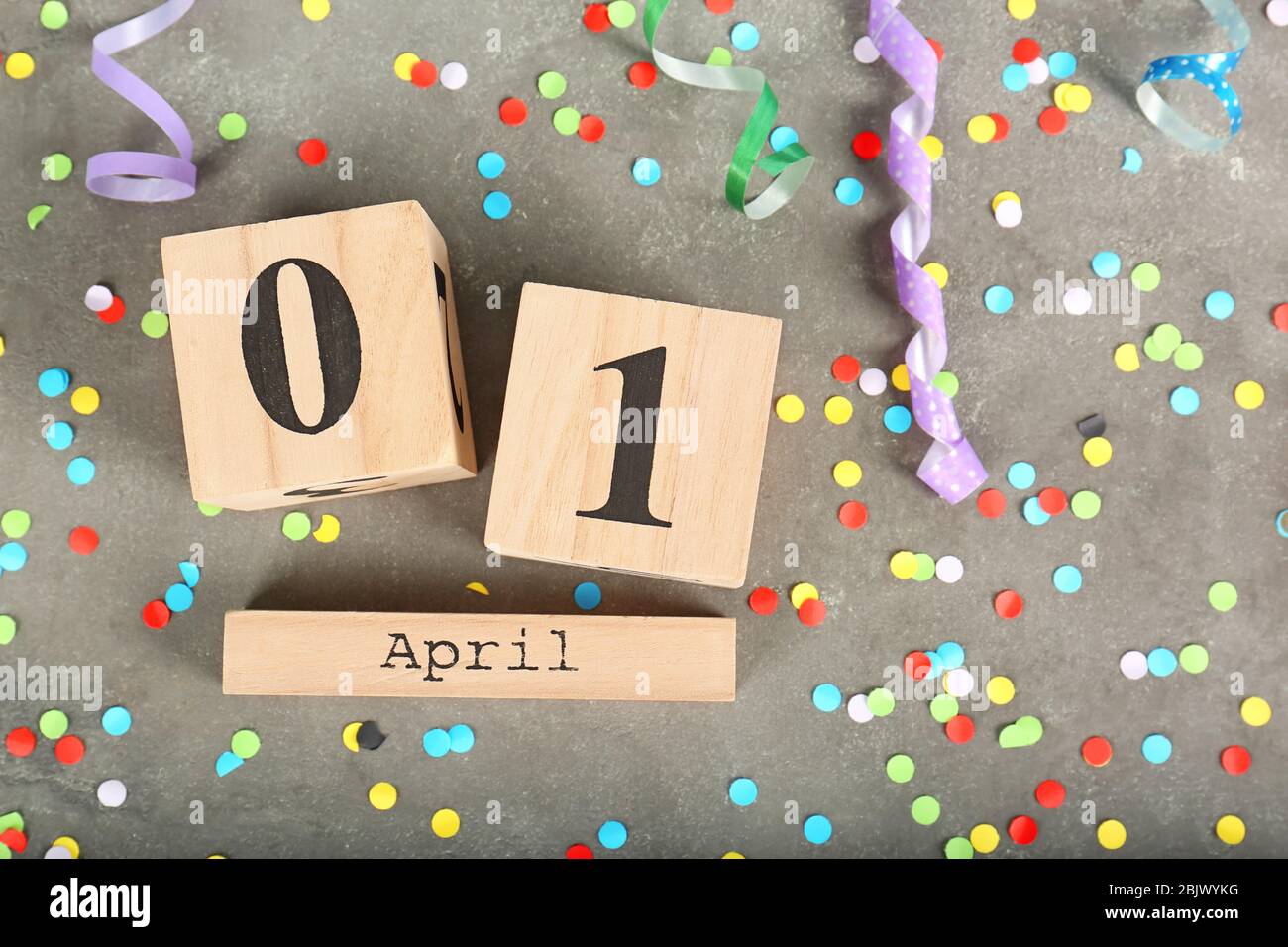 Composition with block calendar and confetti on grey background. April ...