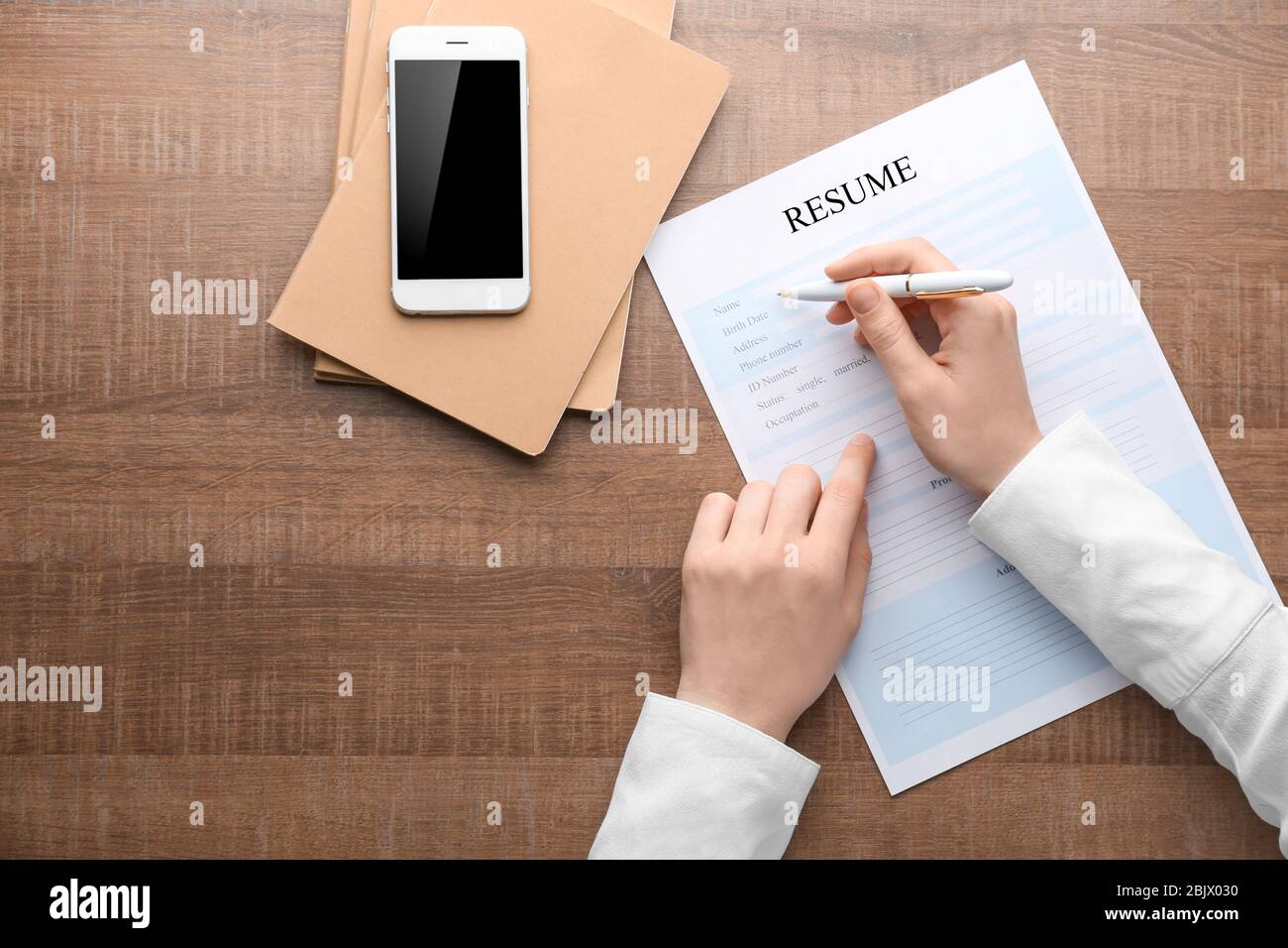 Woman filling in resume form at table. Job interview concept Stock ...