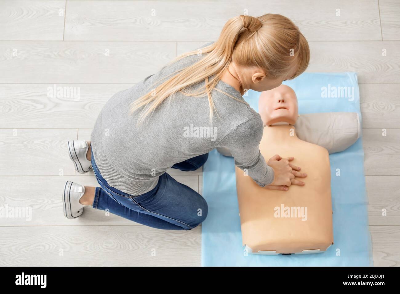 Woman practicing CPR on mannequin at first aid class Stock Photo - Alamy