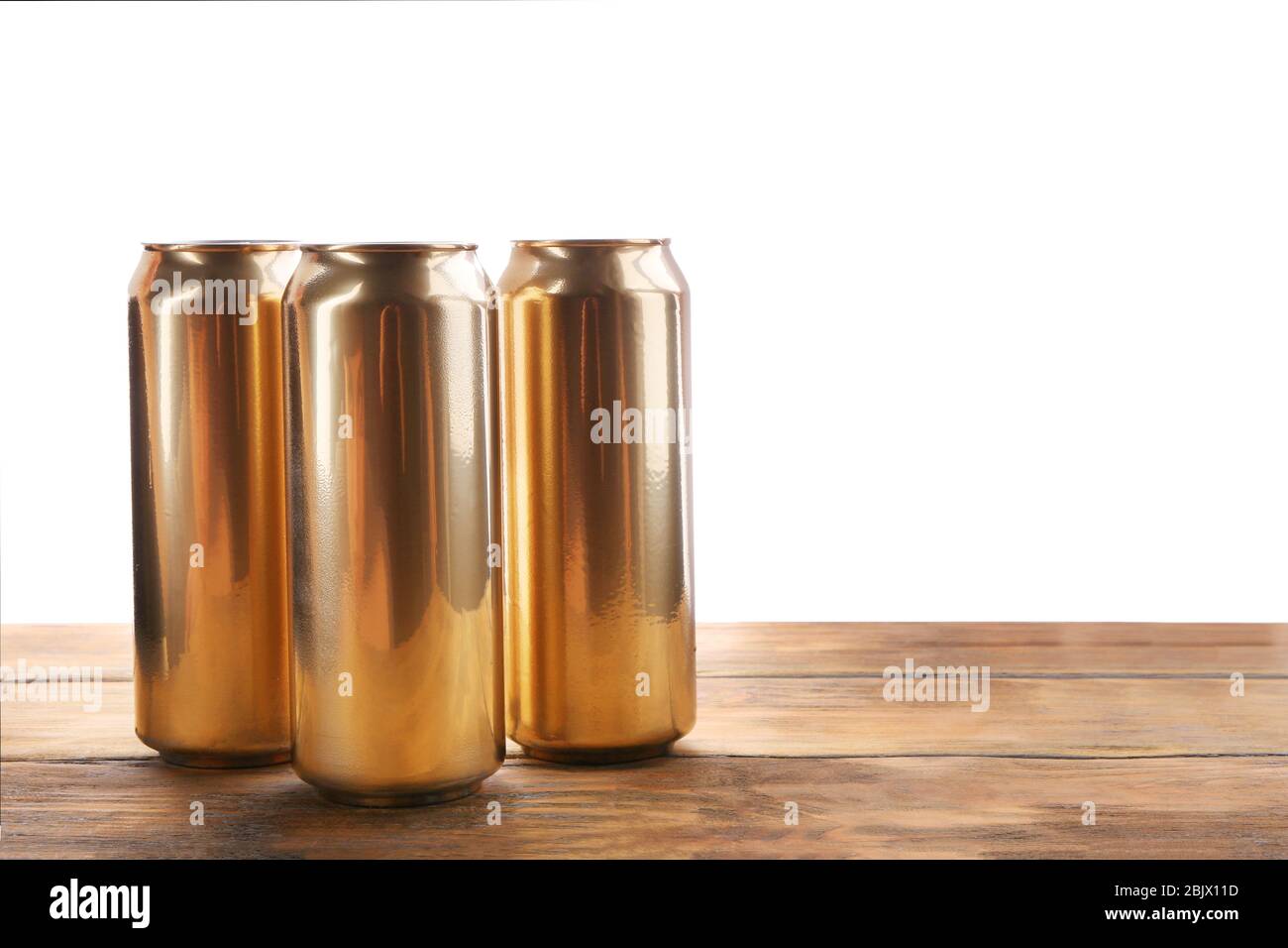 Cans of beer on wooden table against white background Stock Photo - Alamy