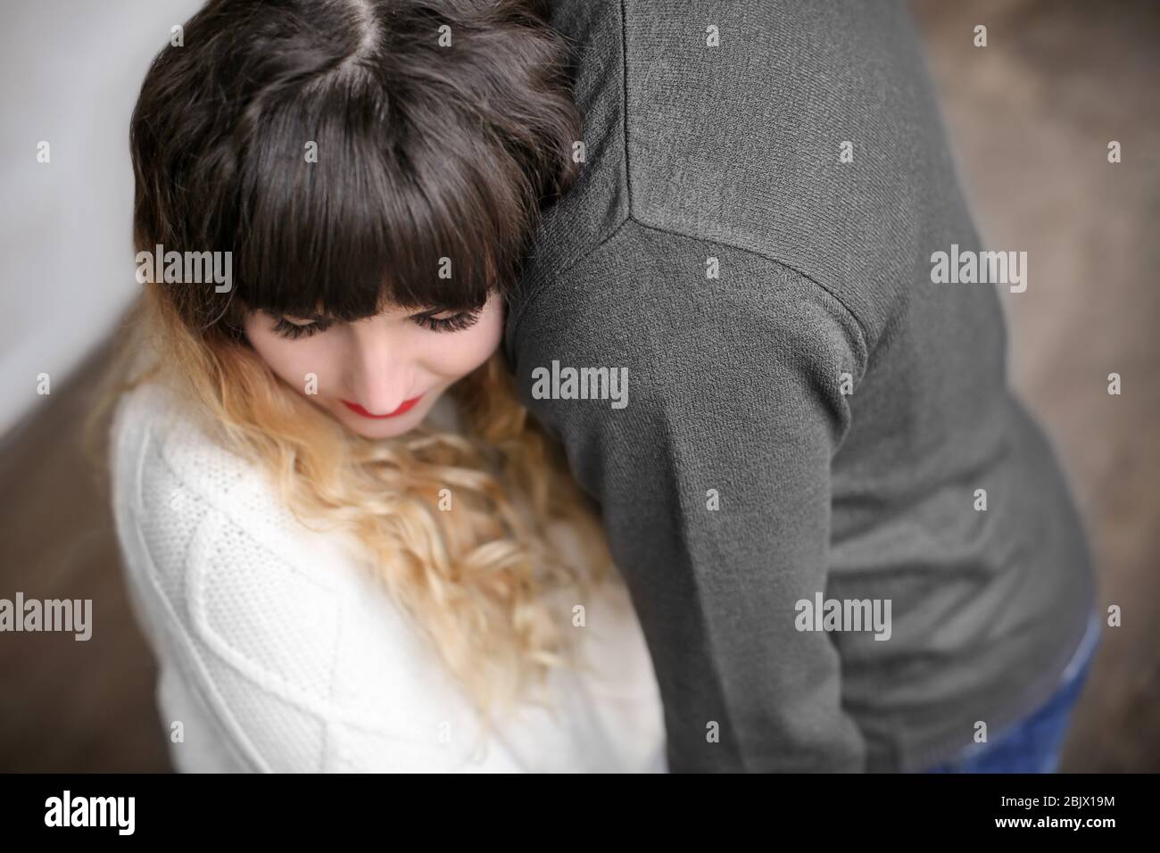 Young woman hugging her boyfriend indoors Stock Photo - Alamy