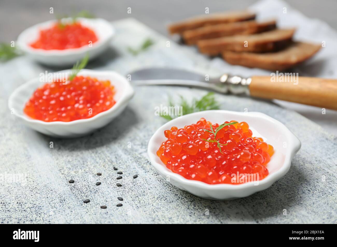 Little plates with delicious red caviar on table Stock Photo - Alamy