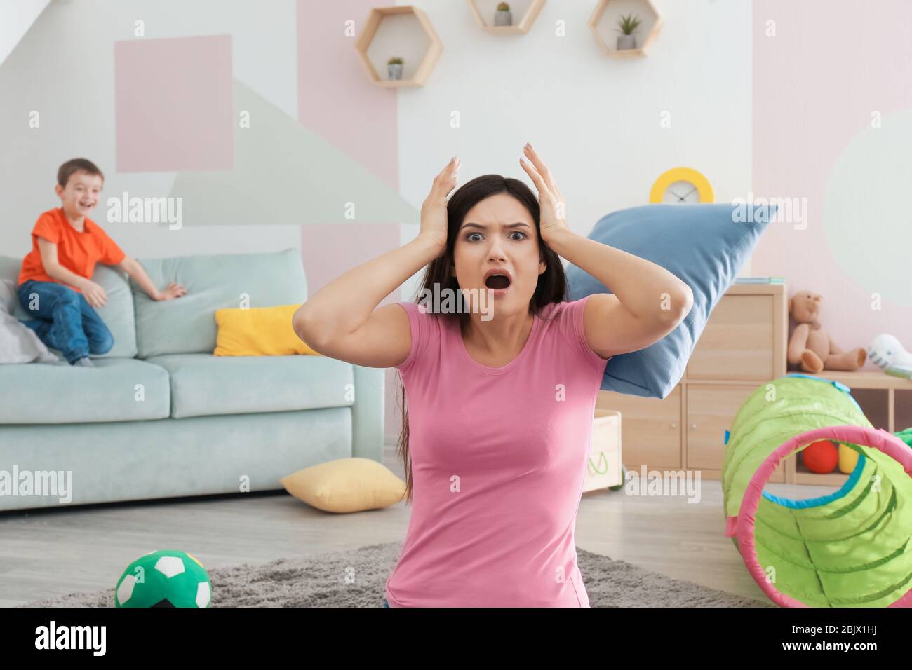 Young nanny in despair and troublesome child at home Stock Photo - Alamy