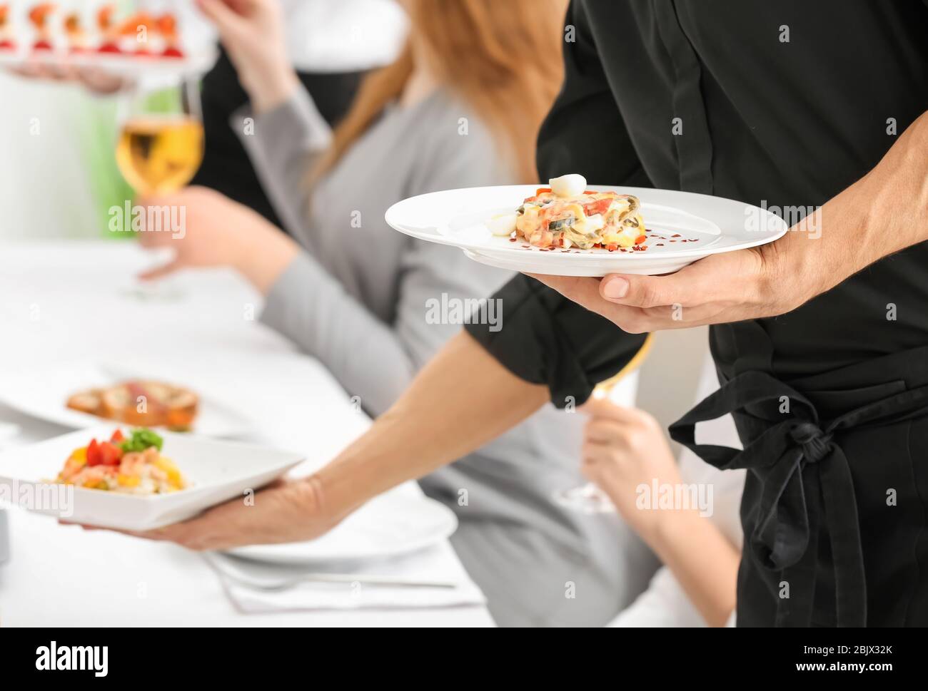 Waiter serving tasty dishes at restaurant Stock Photo - Alamy