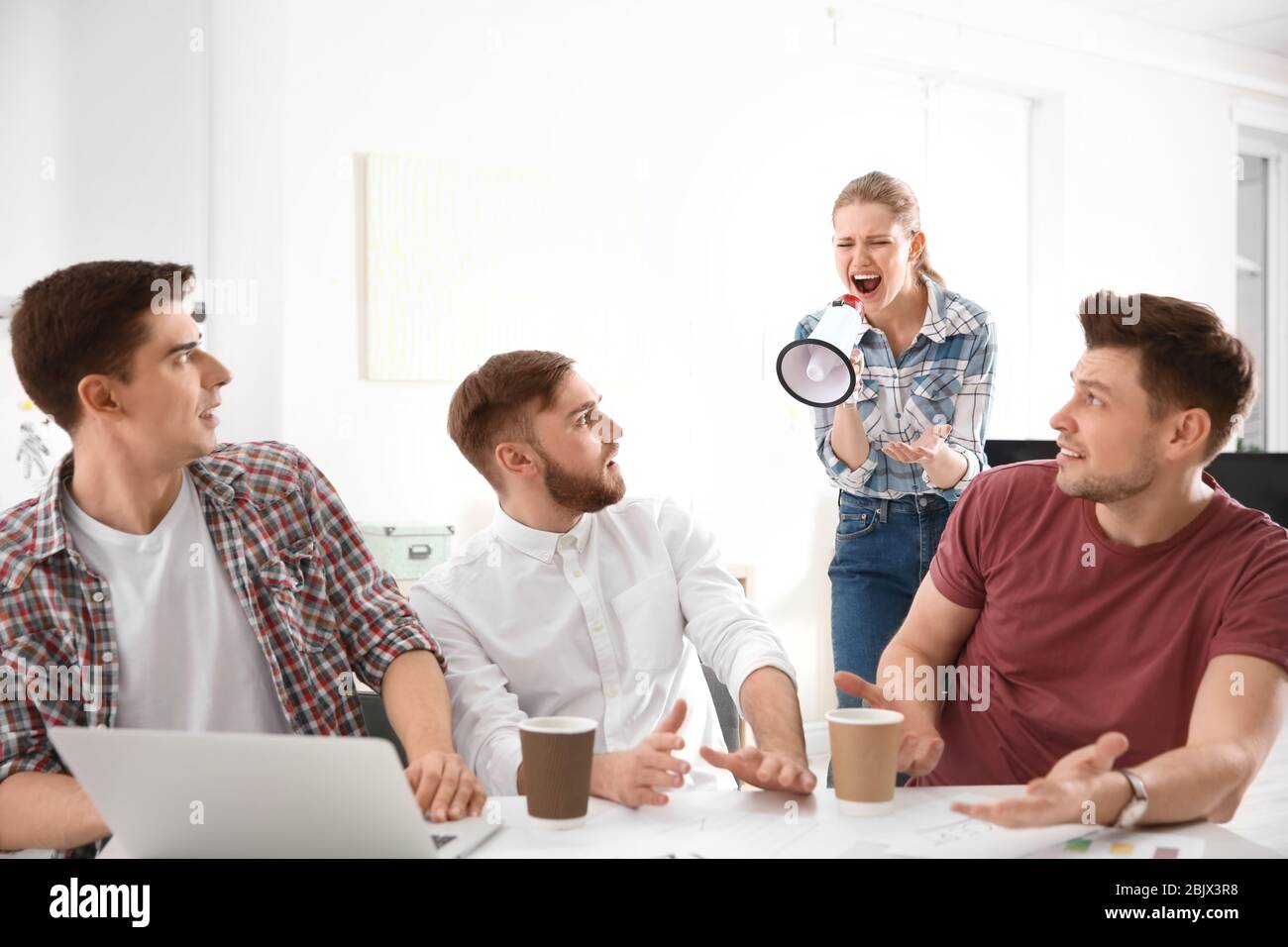 Angry boss with megaphone screaming at employees in office Stock Photo ...