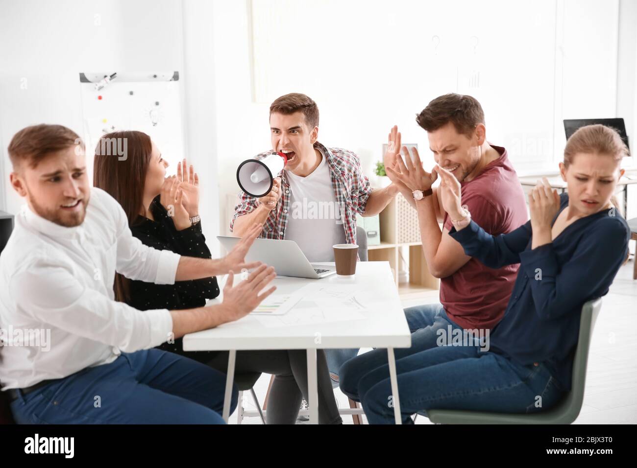 Angry boss with megaphone screaming at employees in office Stock Photo ...