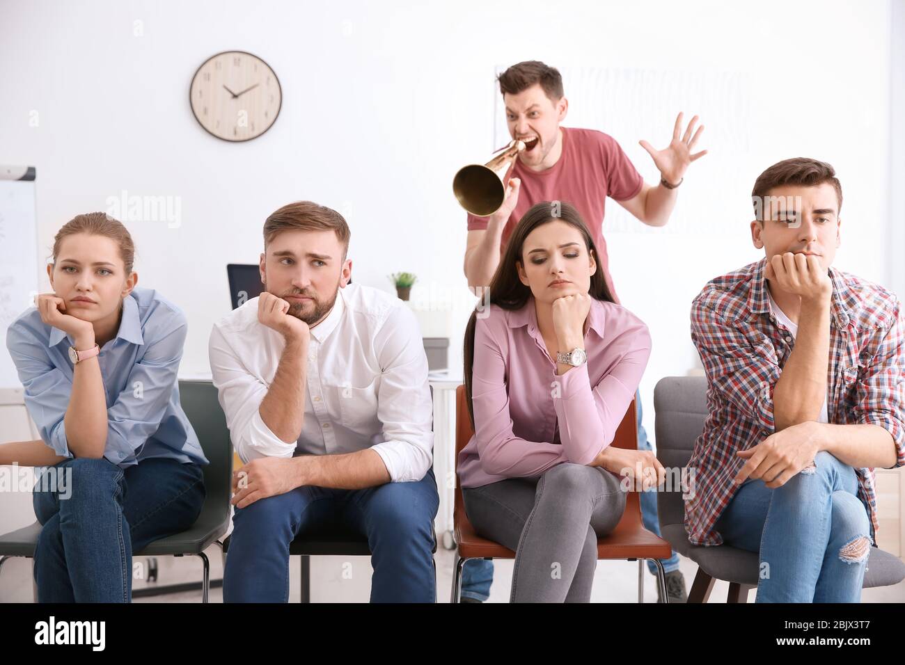 Angry boss with megaphone screaming at employees in office Stock Photo ...