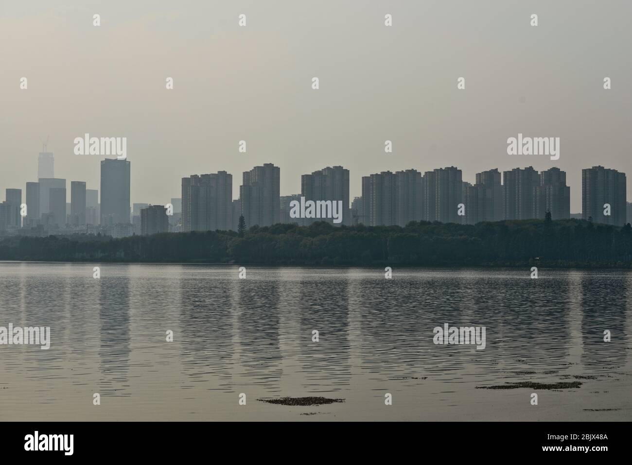 Skyline of Wuhan from the East Lake, with smog and a foggy sky due to ...