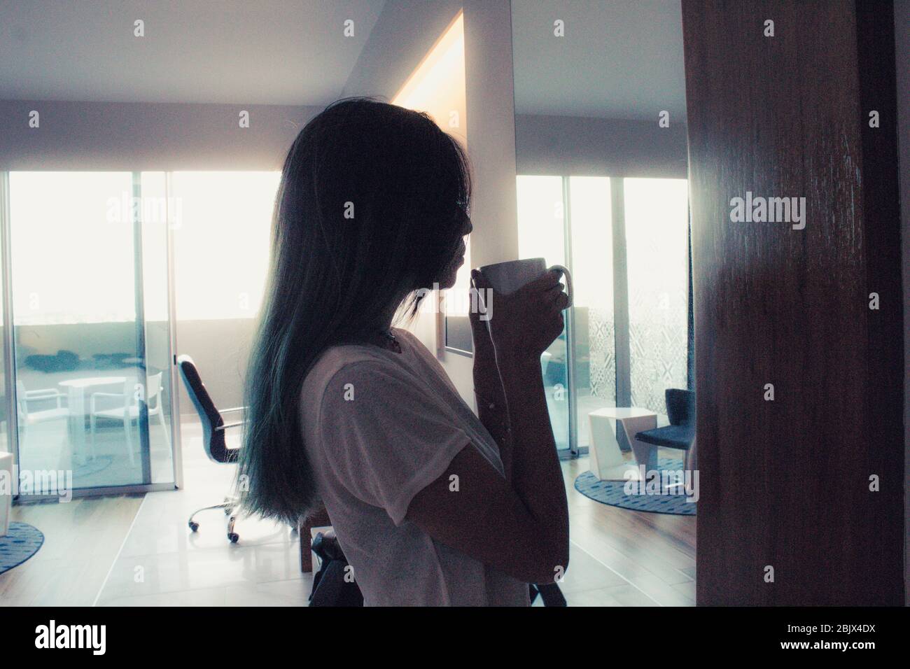 A girld drinking coffe while looking in a mirror Stock Photo - Alamy