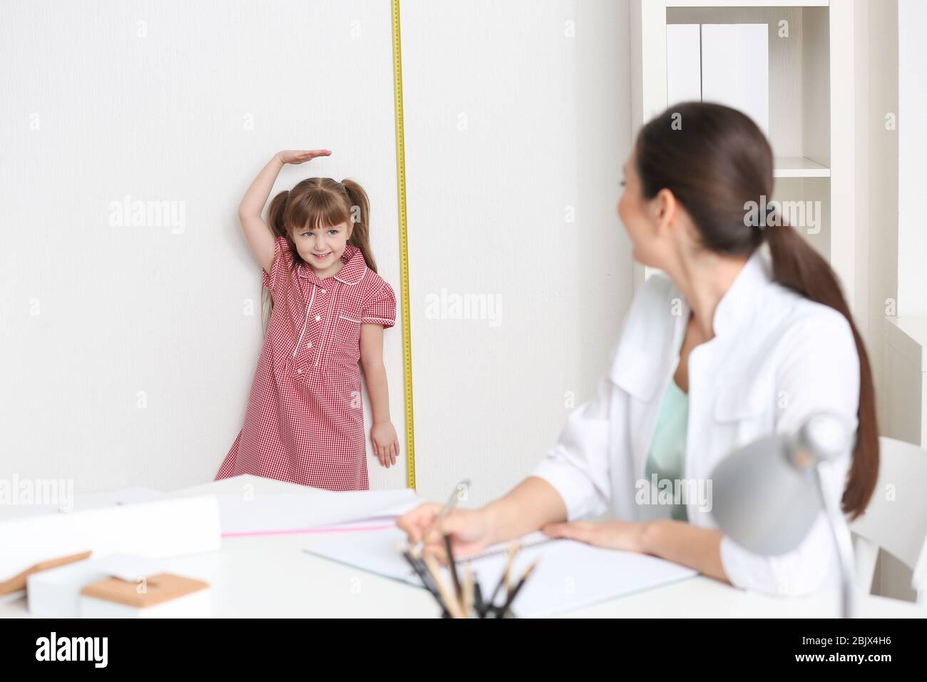 Little girl measuring her height at doctor's office Stock Photo - Alamy