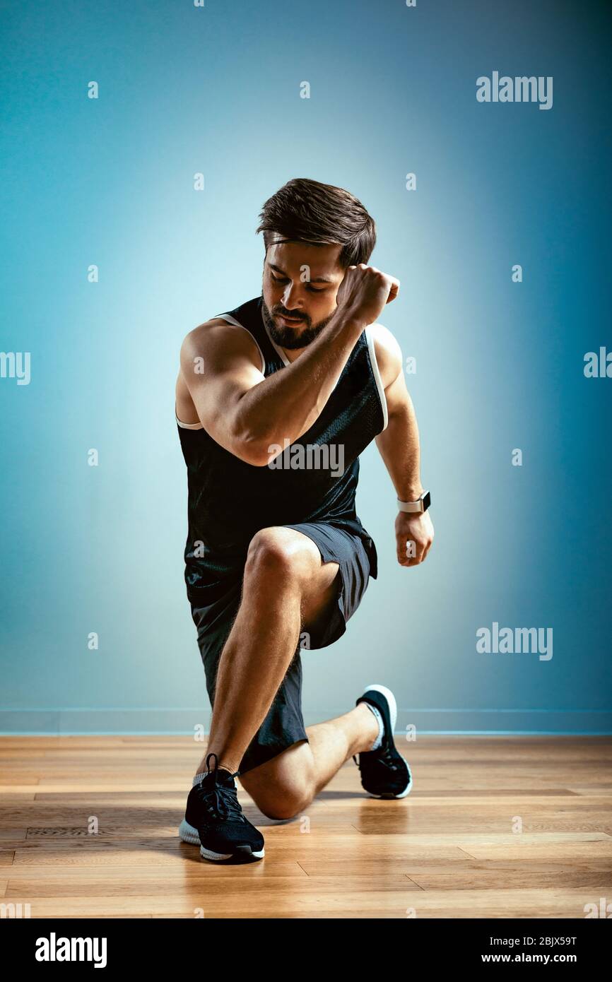 A Man Does Functional Exercises In The Gym On A Gray Background Fitness Concept Sports Body a-man-does-functional-exercises-in-the-gym-on-a-gray-background-fitness-concept-sports-body