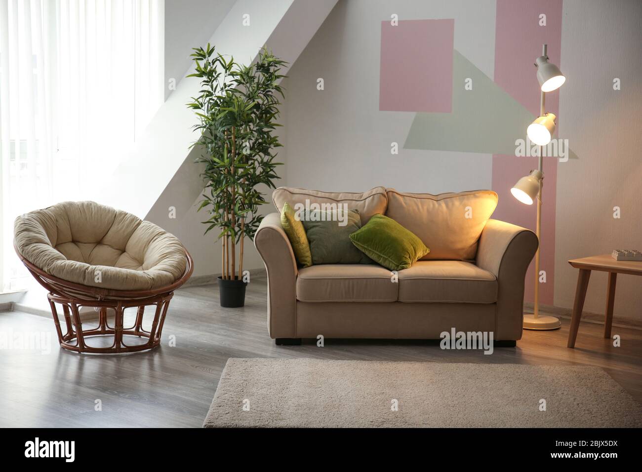 Stylish living room interior with comfortable sofa and lounge chair ...