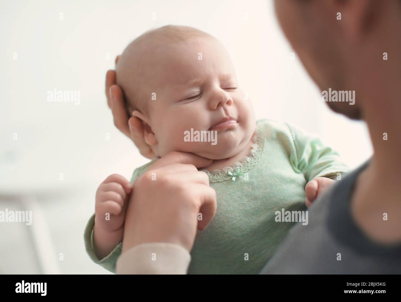 Young parents with sleeping baby at home Stock Photo - Alamy