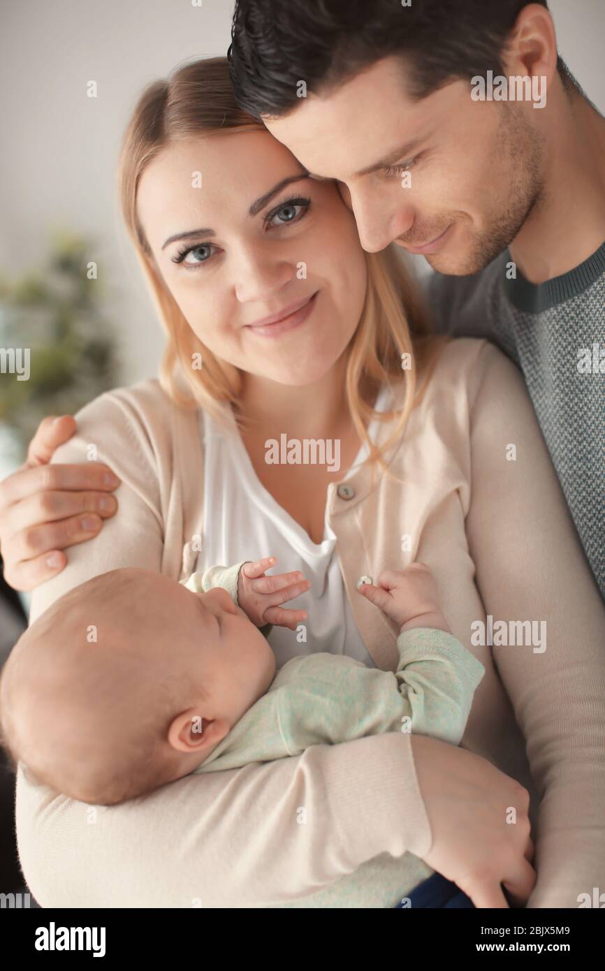 Young parents with sleeping baby at home Stock Photo - Alamy