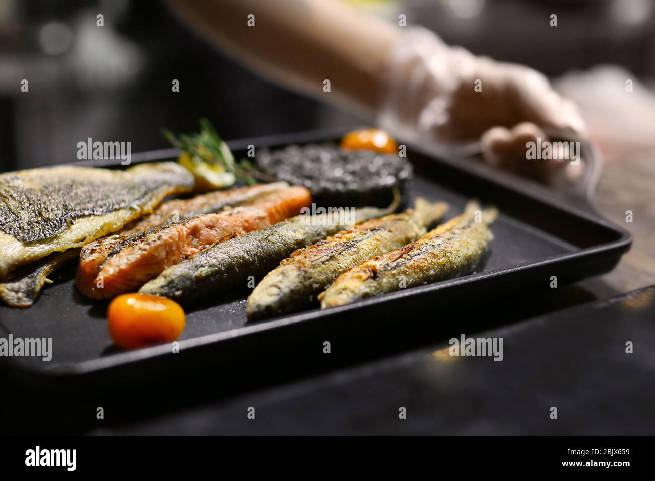 Chef with delicious fried fish platter in restaurant kitchen, closeup ...