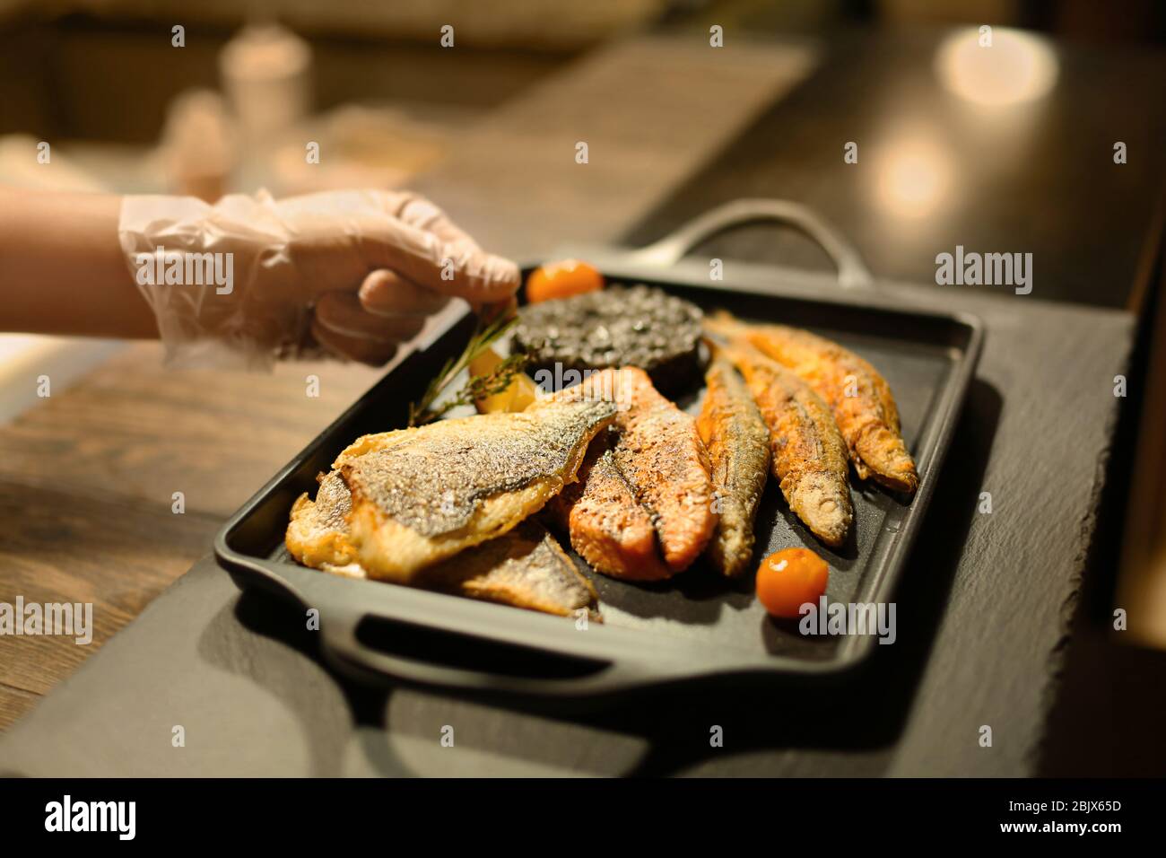 Chef preparing fried fish platter for serving in restaurant Stock Photo ...