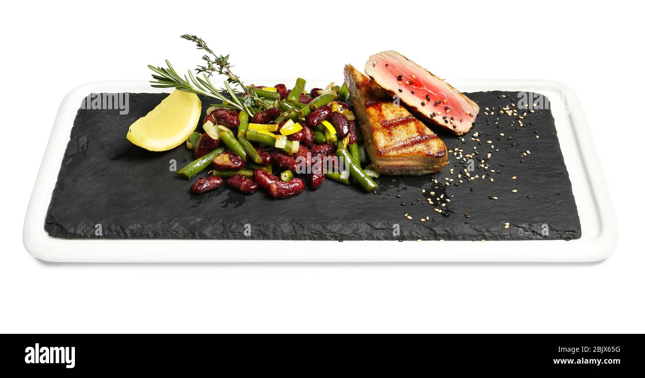 Slate plate with delicious grilled tuna and beans on white background ...