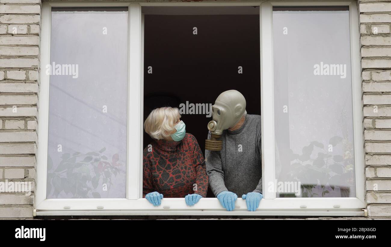 Old grandfather in gas mask and grandmother in protection mask stay at ...