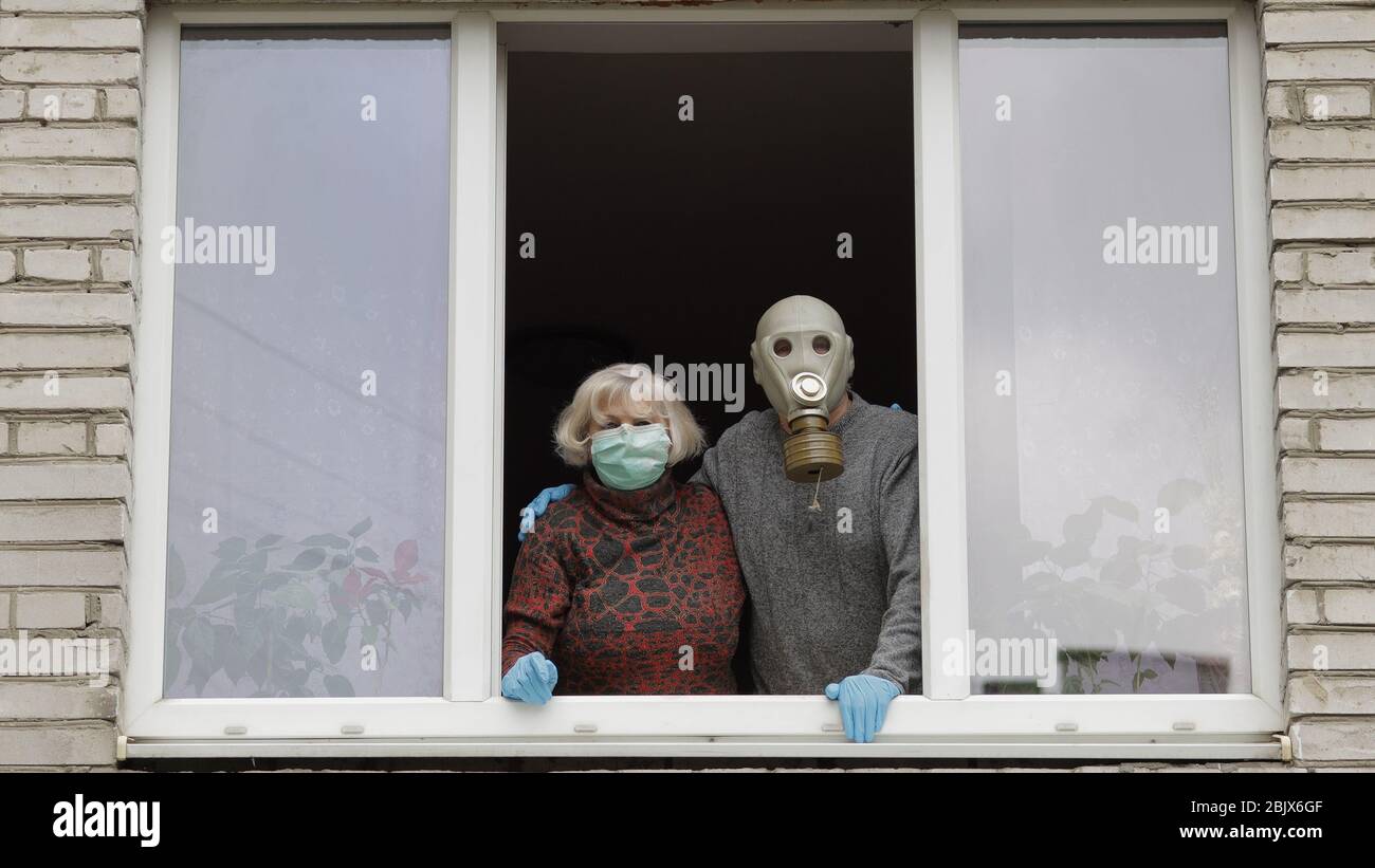 Old grandfather in gas mask and grandmother in protection mask stay at ...