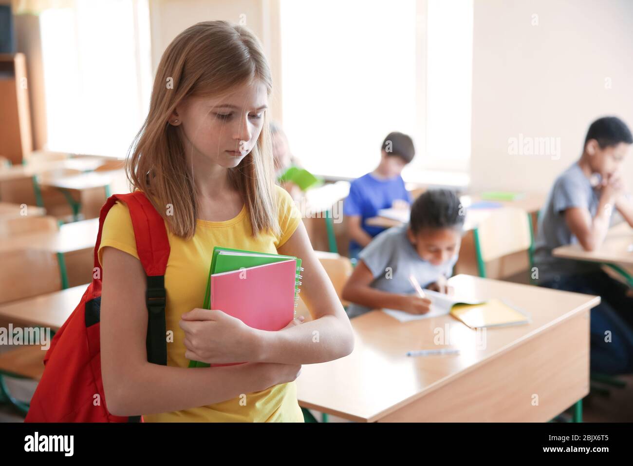 Sad teenage girl in classroom. Bullying at school Stock Photo - Alamy