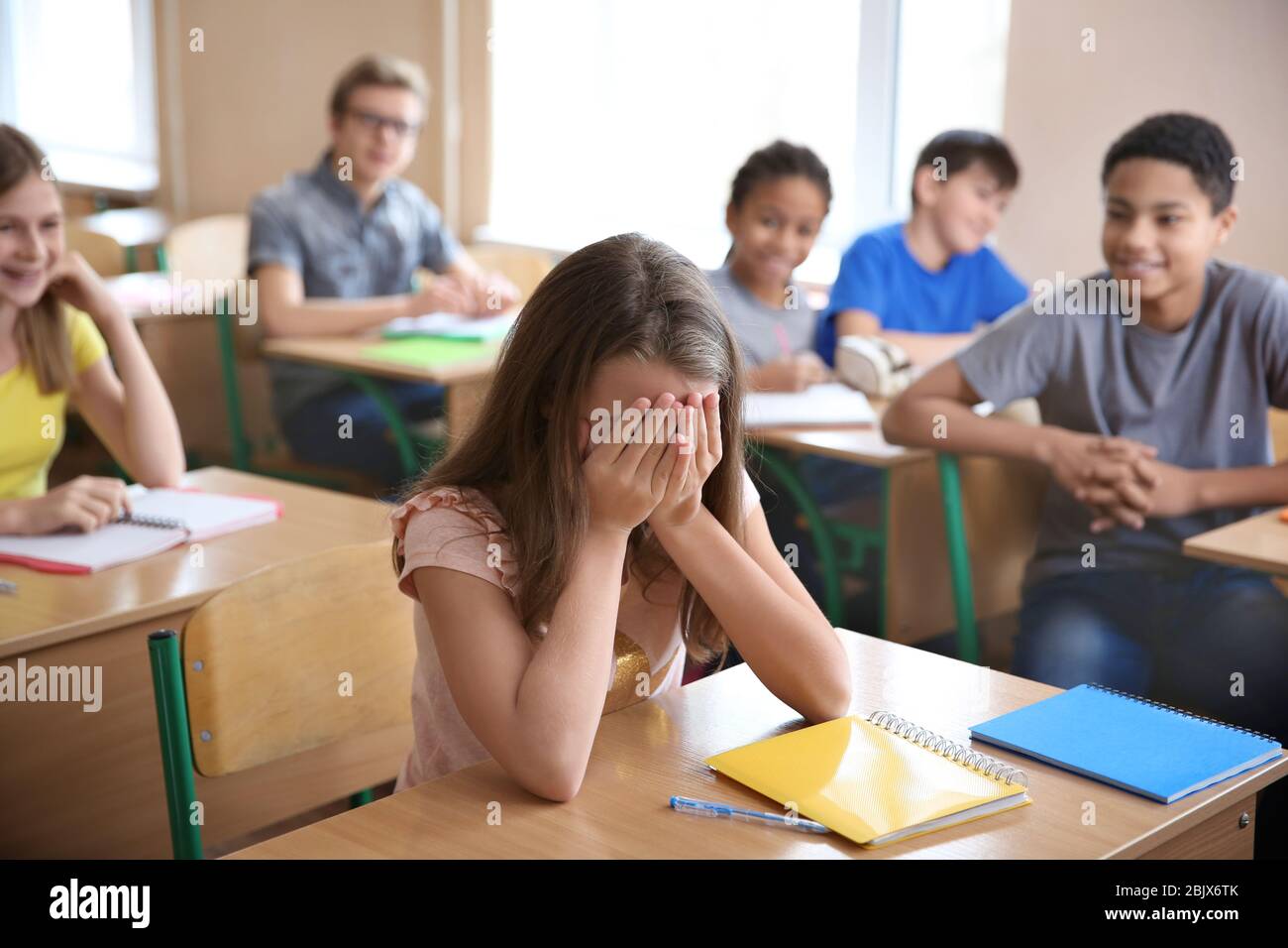 Sad girl sitting in classroom. Bullying at school Stock Photo - Alamy
