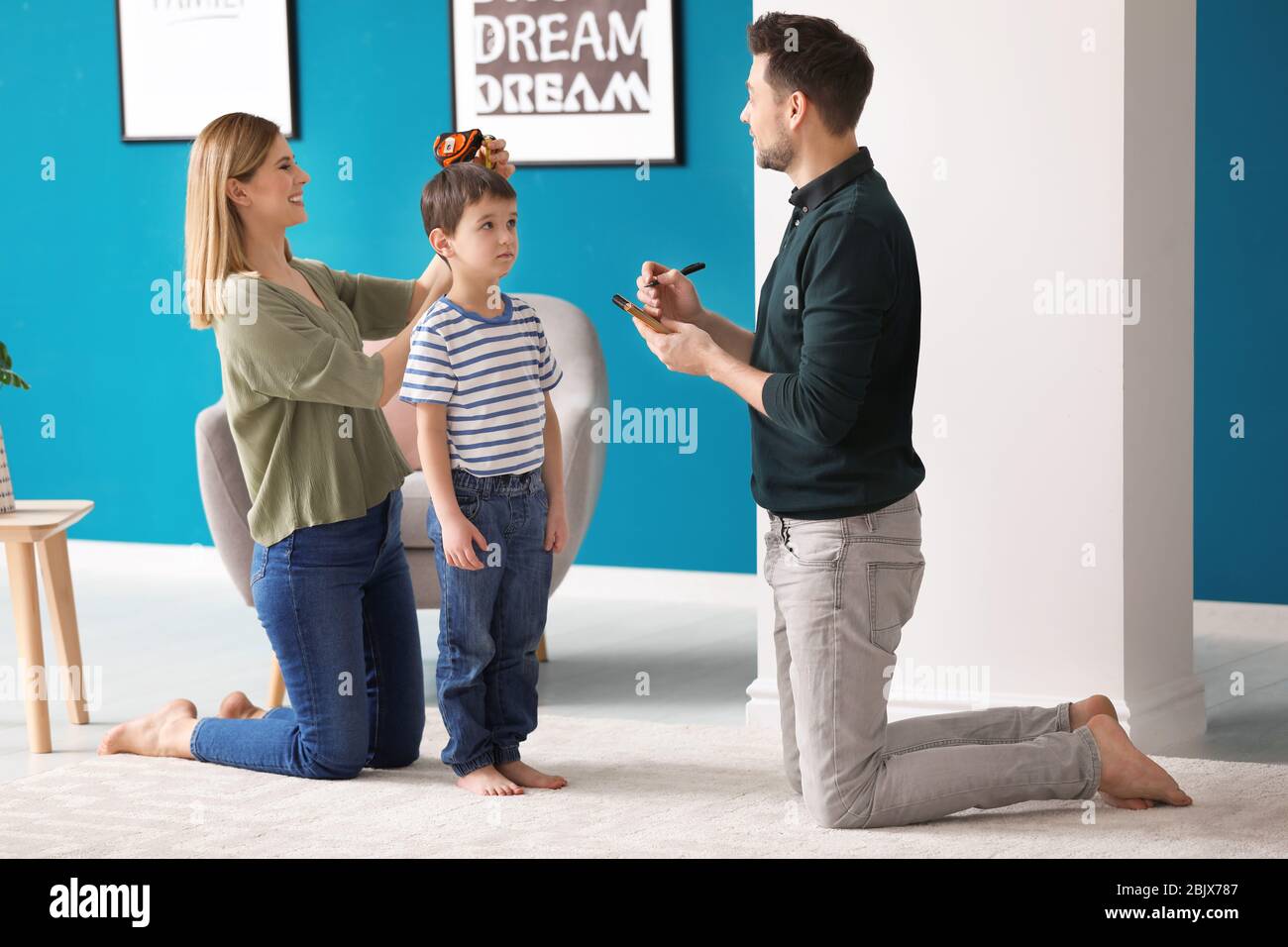 Parents measuring height of their son at home Stock Photo - Alamy