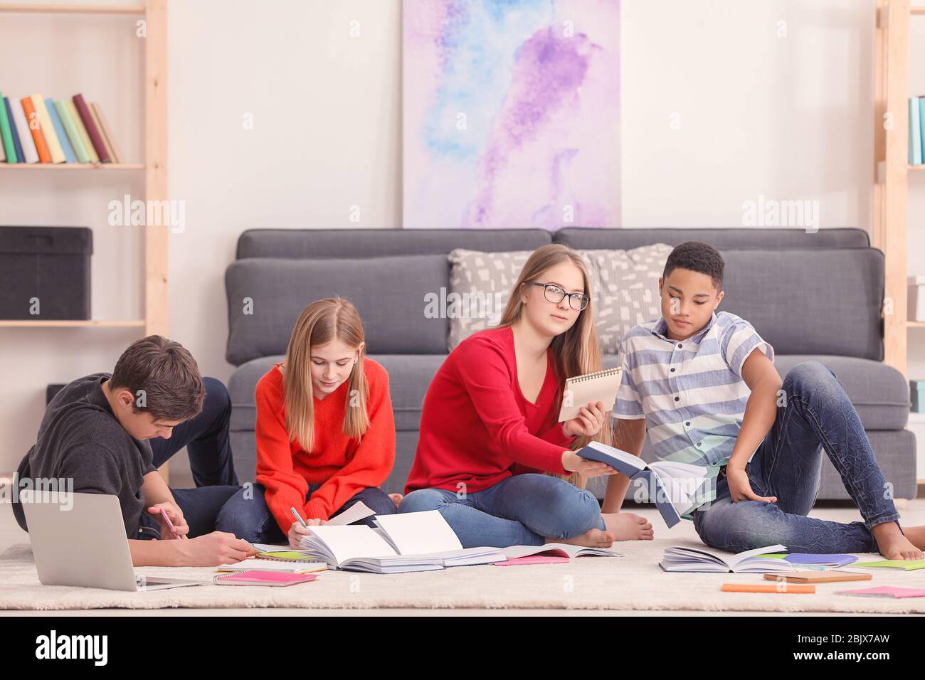 Group of teenagers doing homework on floor Stock Photo - Alamy