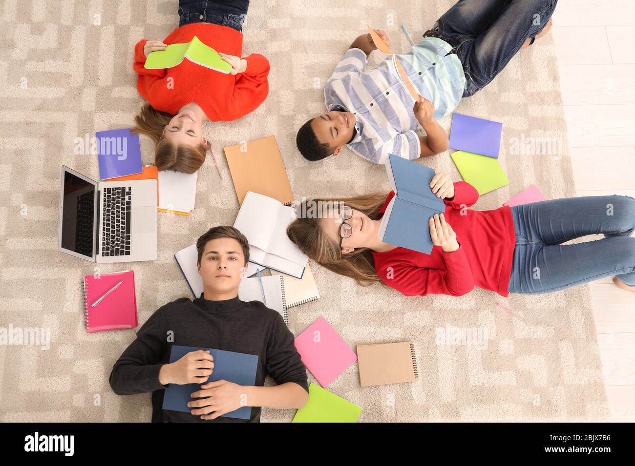 Group of teenagers doing homework on floor Stock Photo - Alamy