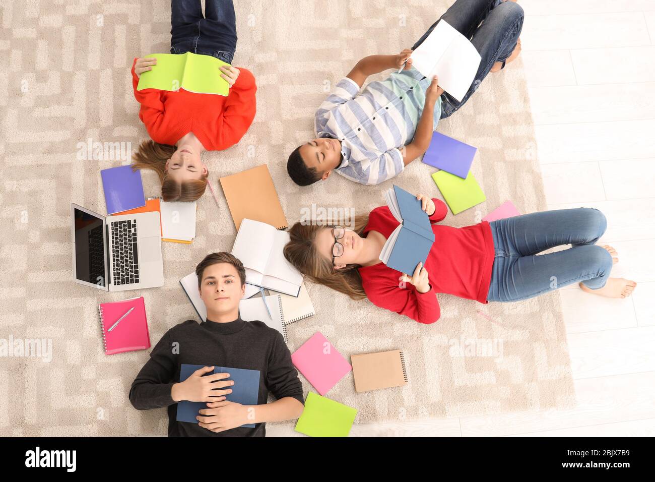 Group of teenagers doing homework on floor Stock Photo - Alamy