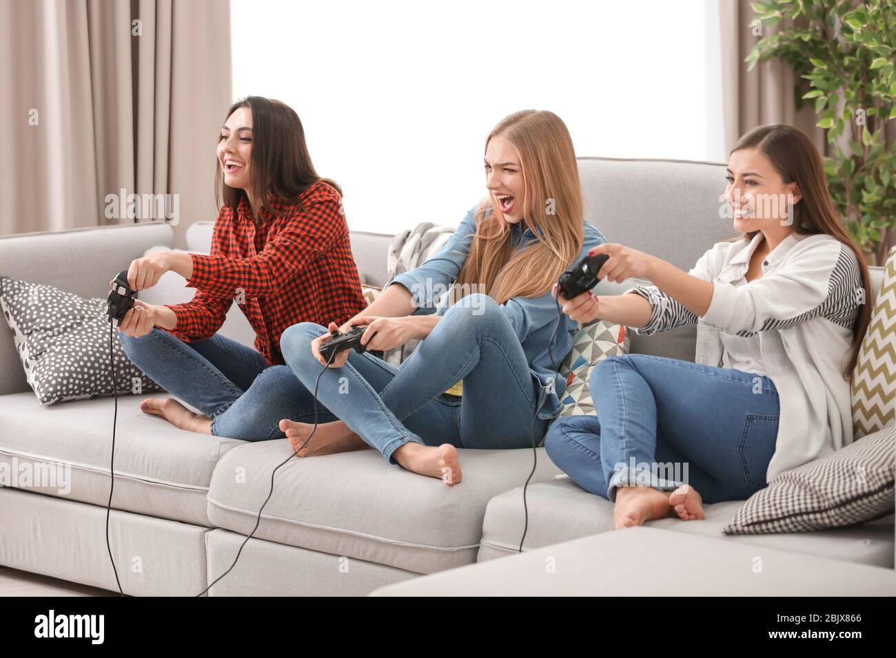 Young women playing video games at home Stock Photo - Alamy