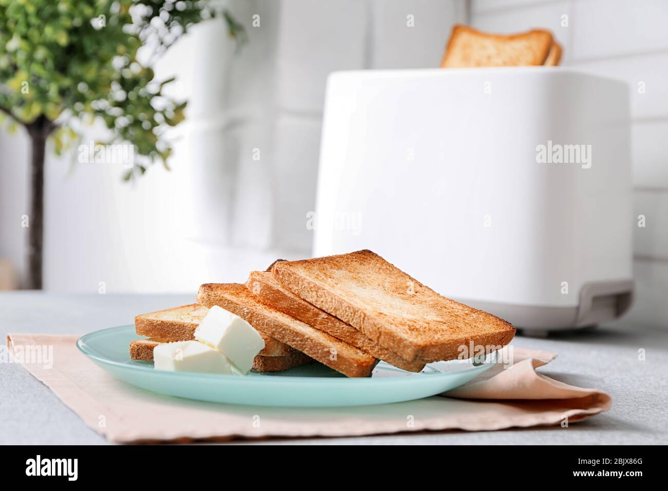 Plate with toasted bread and butter on table Stock Photo - Alamy