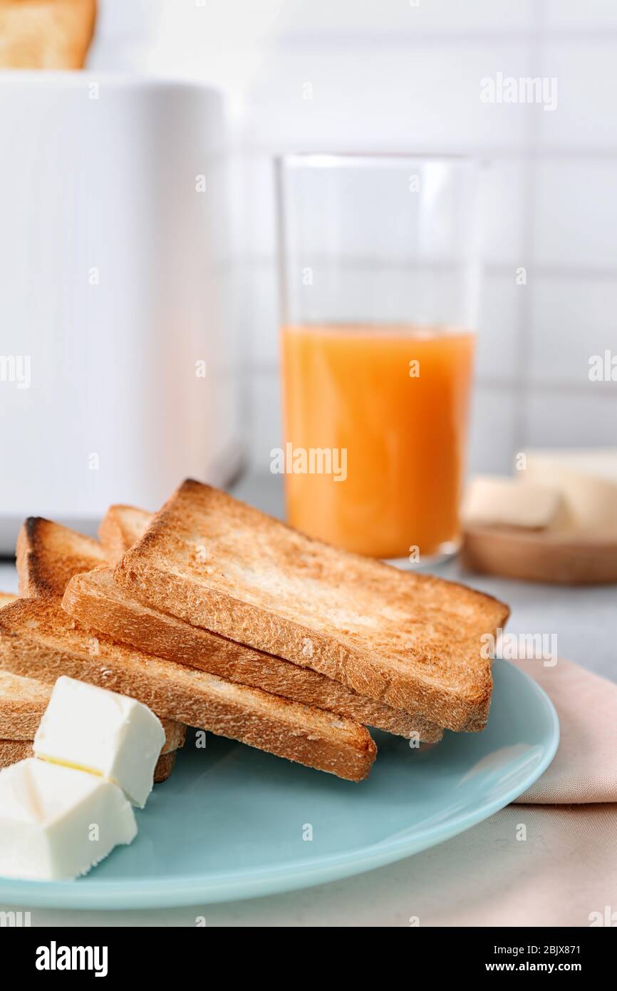 Toasted bread served with butter and juice on table Stock Photo - Alamy