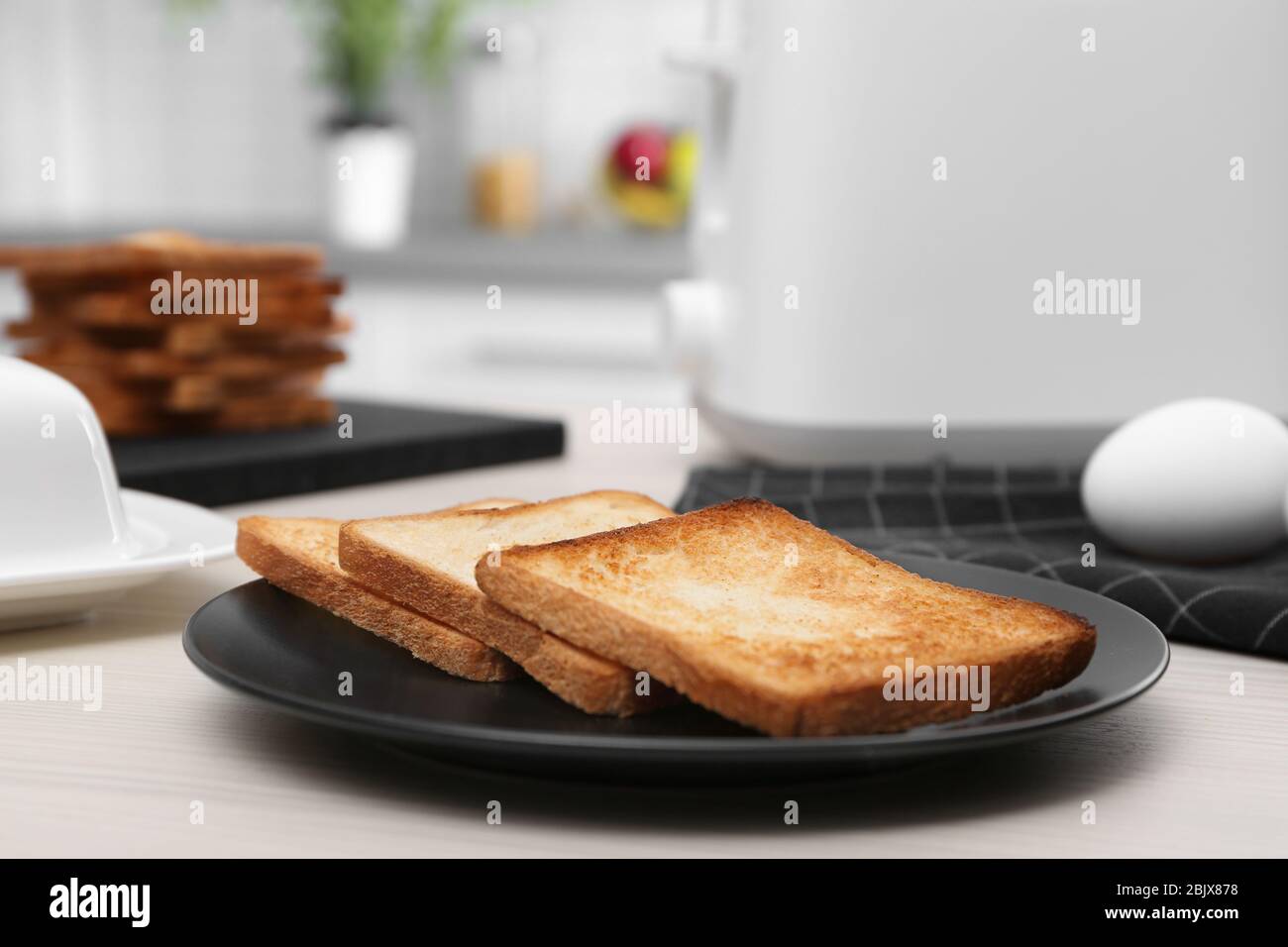 Plate with toasted bread on table Stock Photo - Alamy