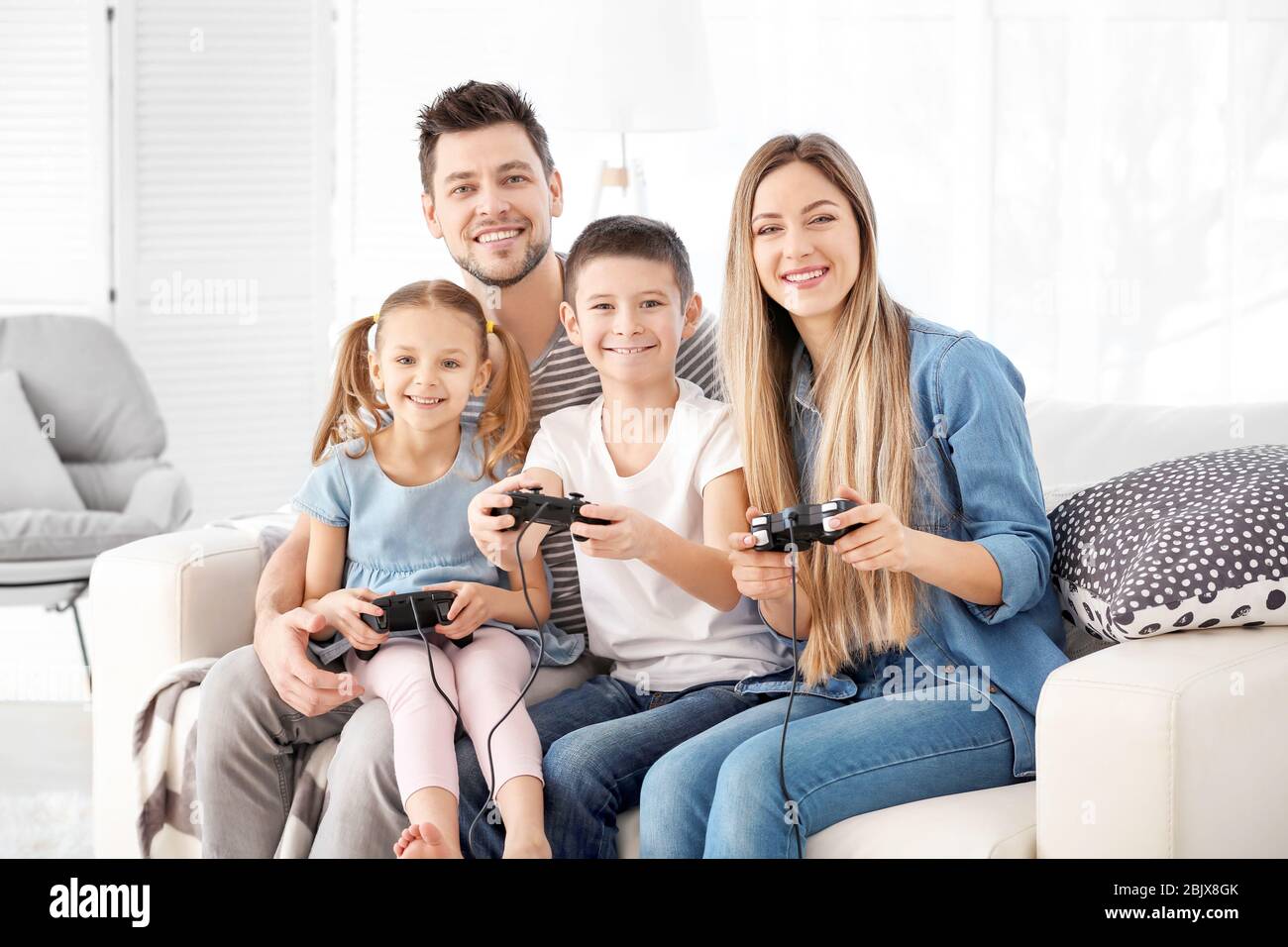 Happy family playing video games at home Stock Photo - Alamy